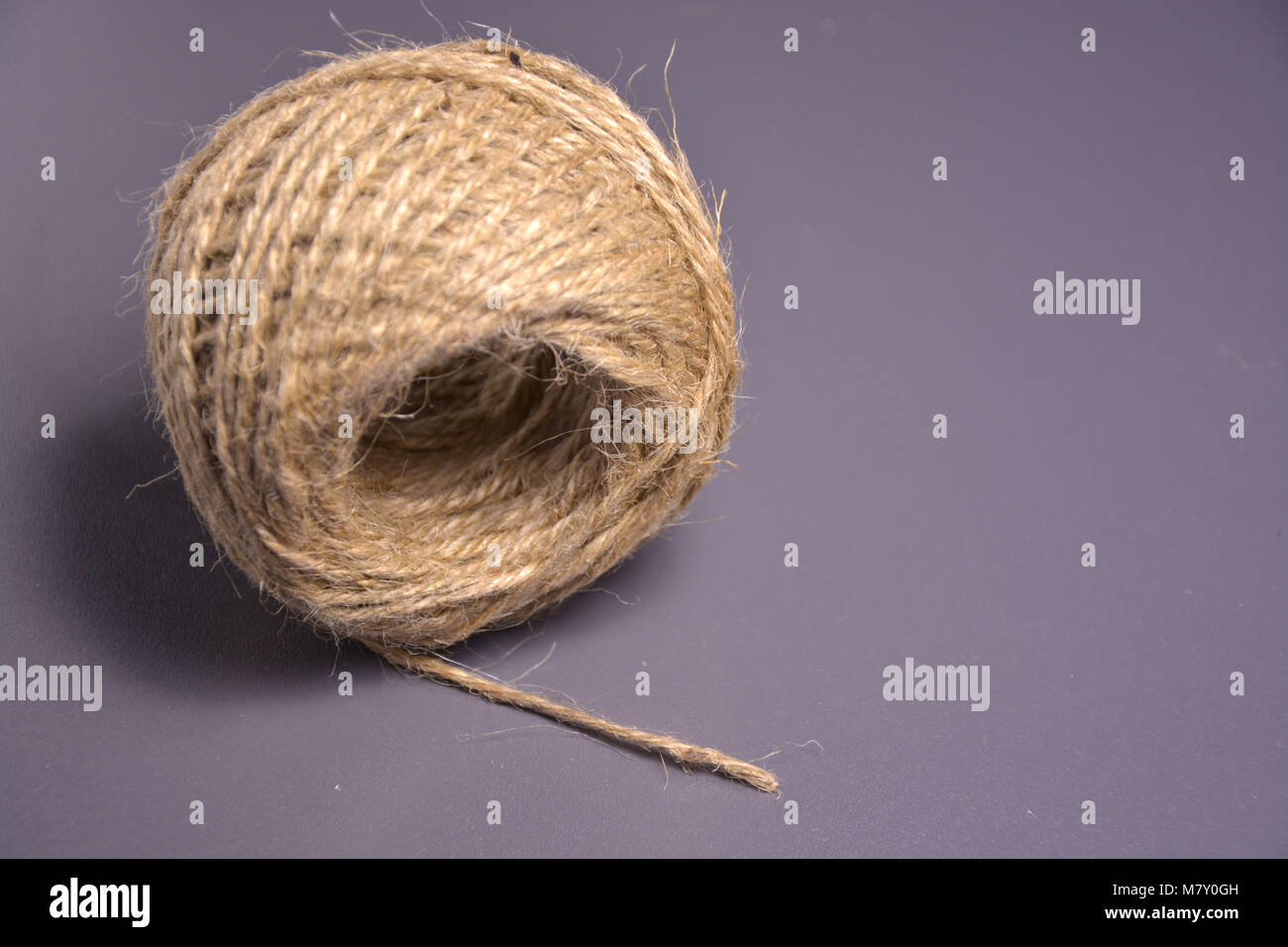 Jute string, roll rope on gray background Stock Photo - Alamy