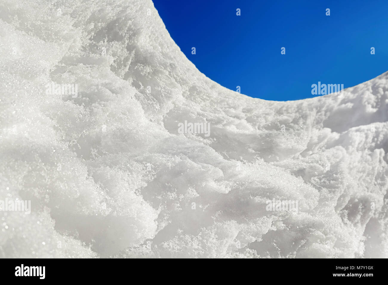 Closeup white snow detail structure with blue sky Stock Photo - Alamy
