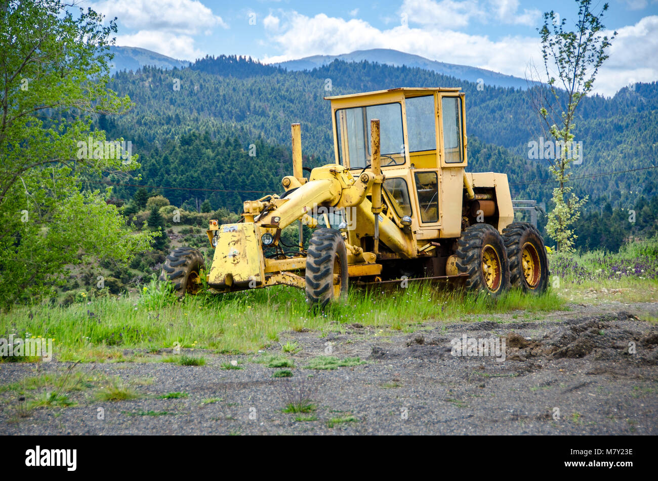 Old grader on mountainous road construction Stock Photo - Alamy