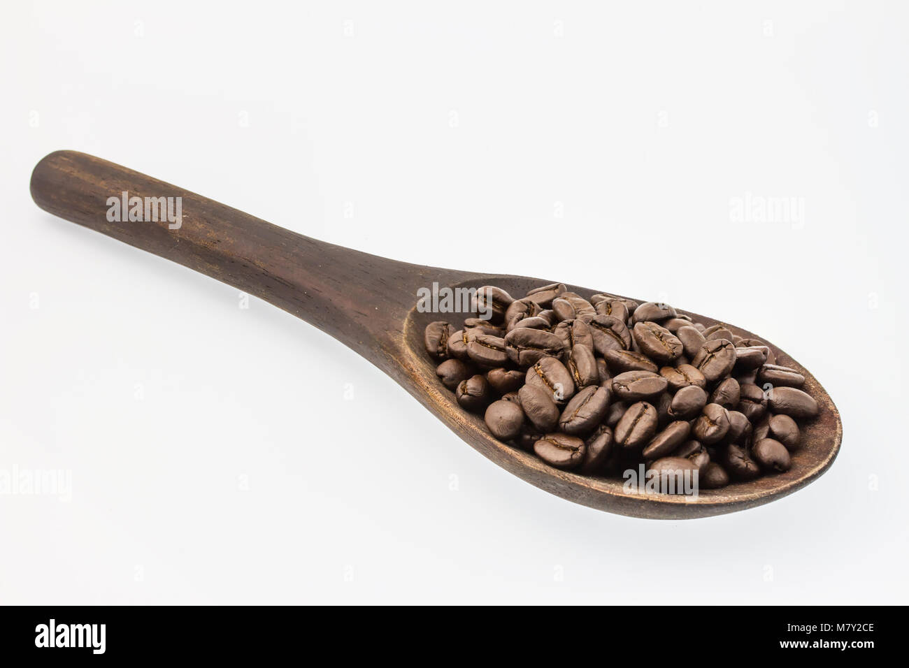 Raw coffee in wooden ladle on white background Stock Photo - Alamy