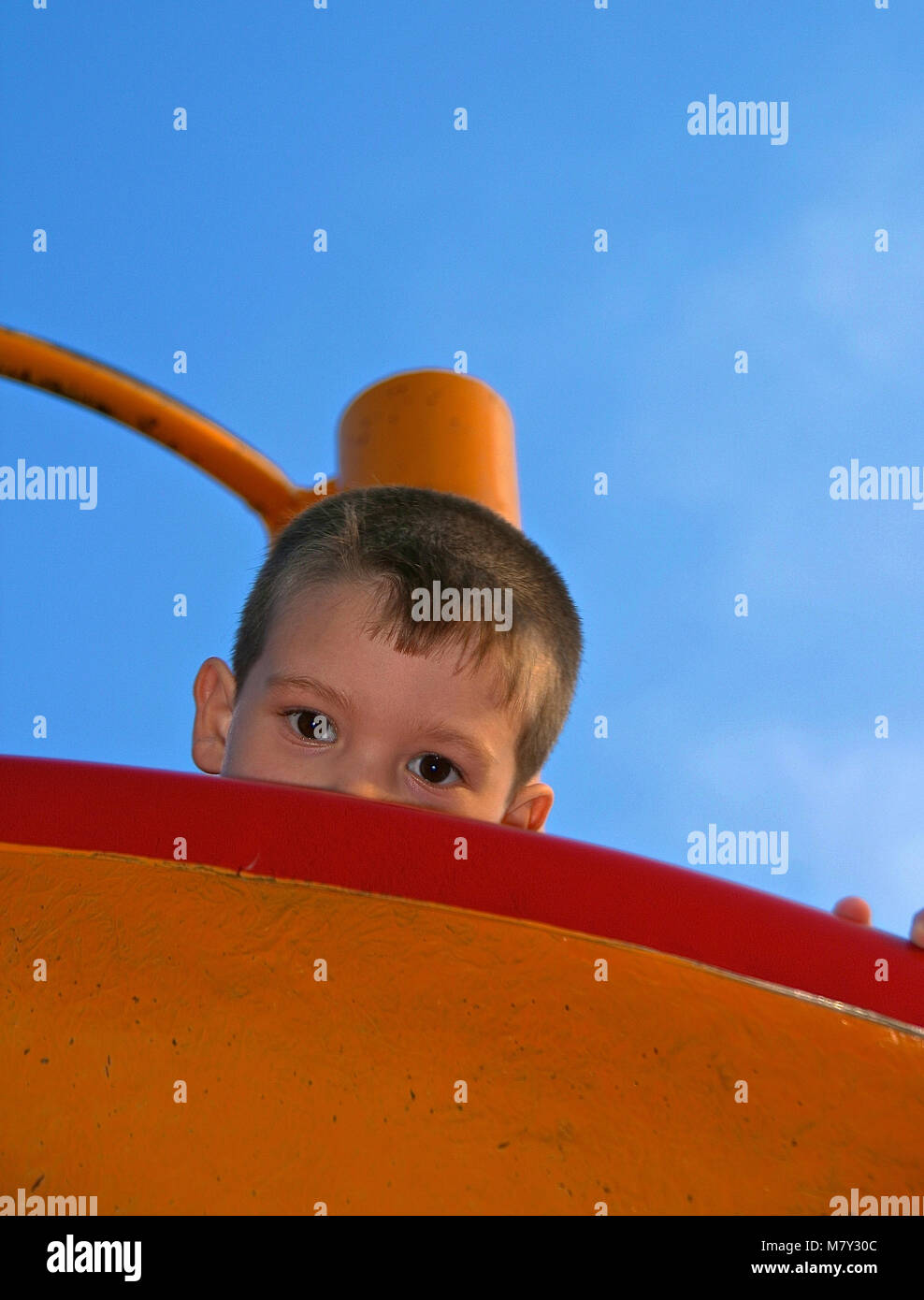 Child hiding while playing on playground Stock Photo - Alamy