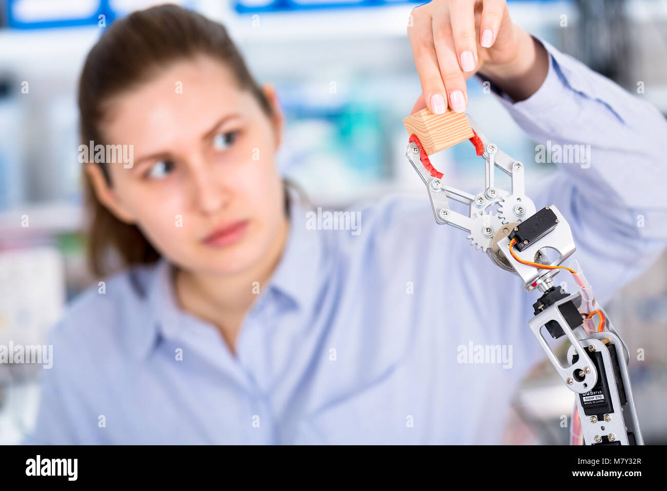A girl in a University laboratory is experimenting with a robot Stock ...