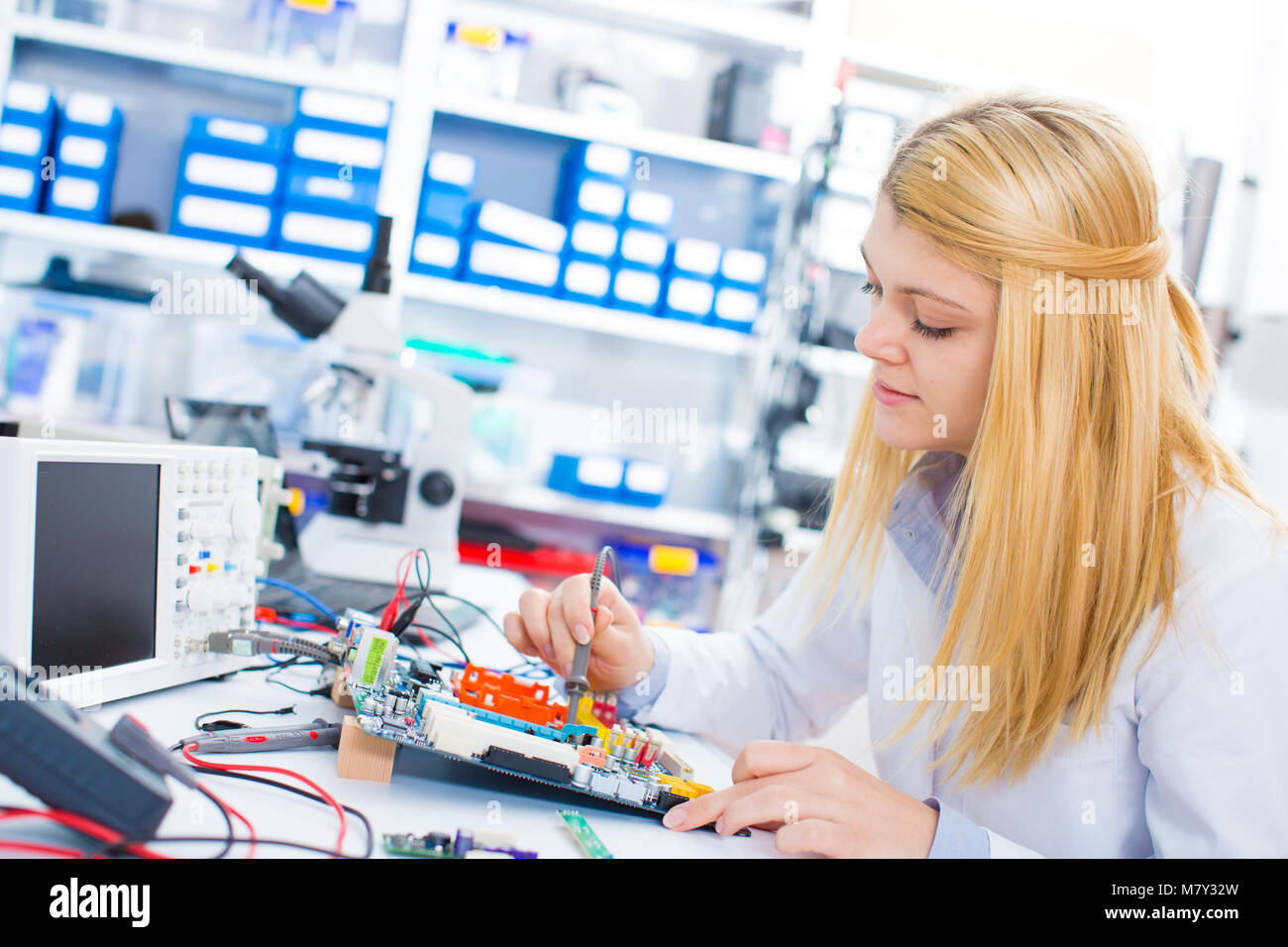 Female laboratory assistant Repairs PCB module for CNC robotics ...