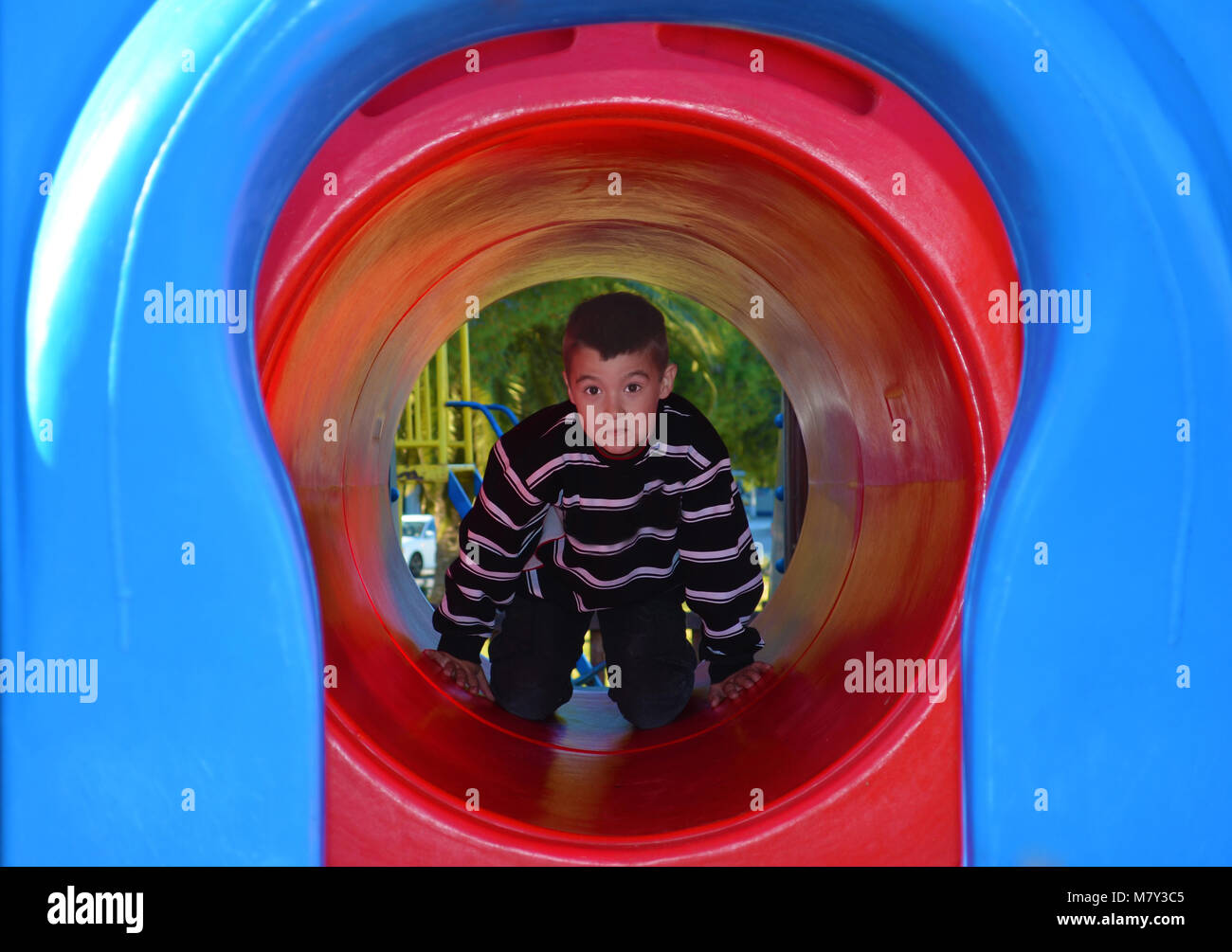 Boy's playing at playground in a colorful tube Stock Photo - Alamy