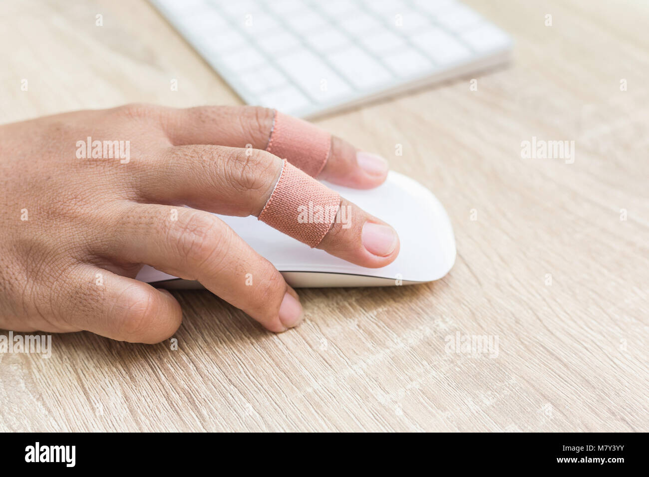 Close up hand with injury on finger using white computer wireless mouse ...