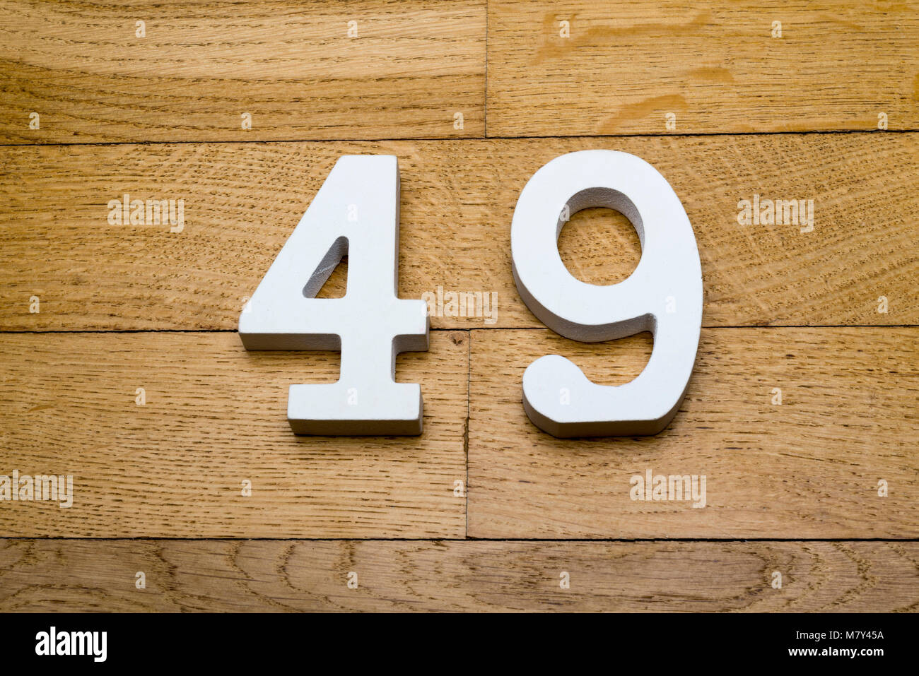 Figure forty-nine on a wooden, parquet floor as a background Stock ...