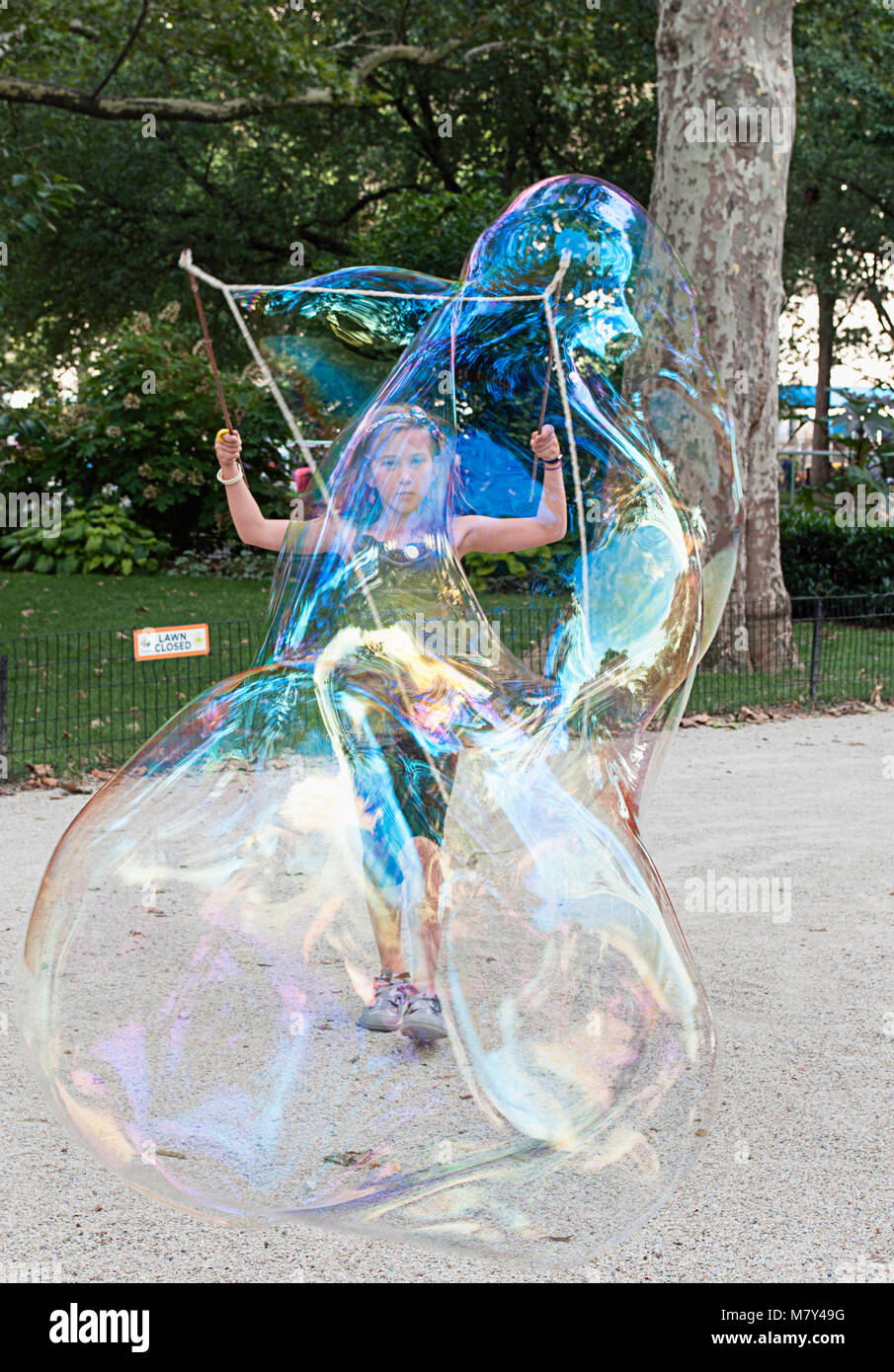 A girl making a giant bubble at Madison Park, New York City Stock Photo ...