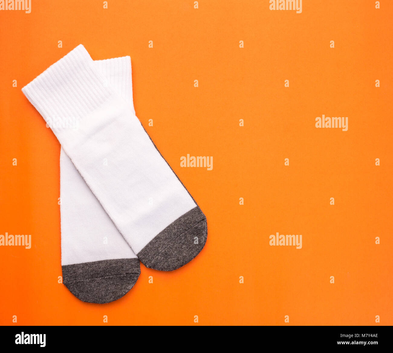 Top view new white student sock on orange background with free space ...