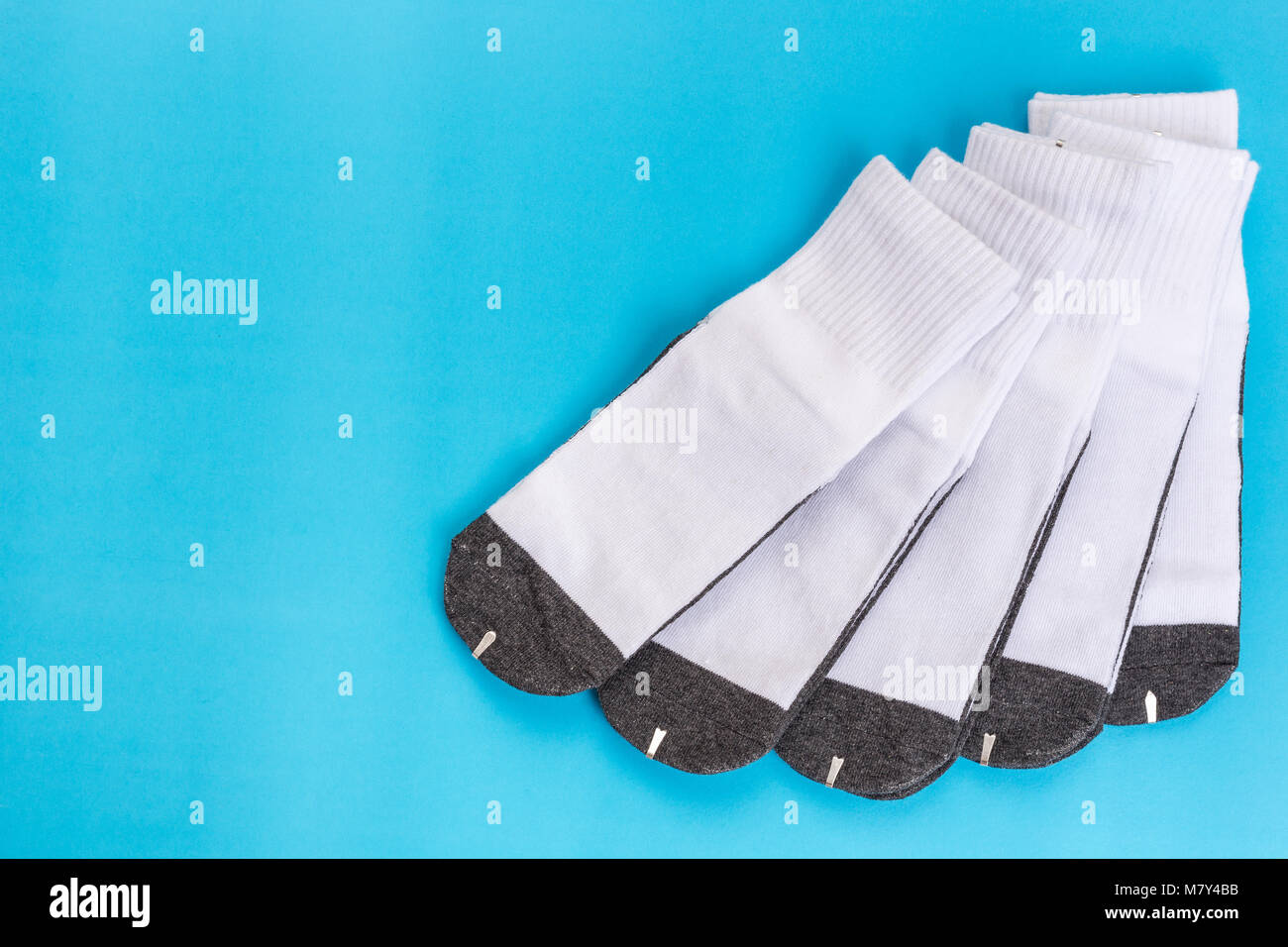 Top view new white student sock on blue background with free space for ...