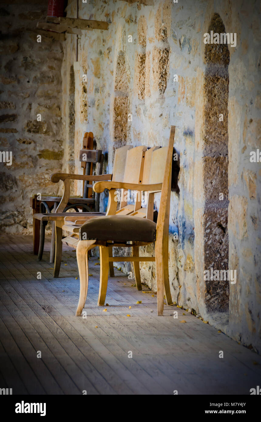 Old chairs in balcony with wooden floor and stone made walls. Orthodox ...
