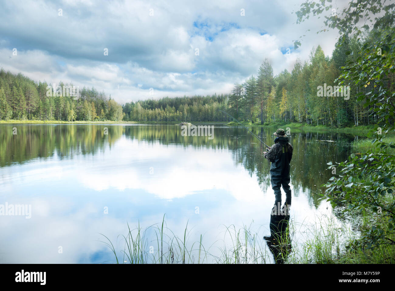 Man fishing on a lake Stock Photo - Alamy