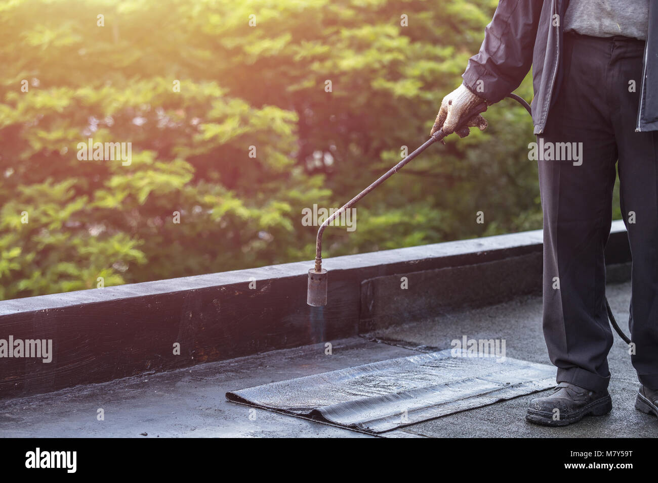 Asia worker installing tar foil on the rooftop of building. Waterproof ...