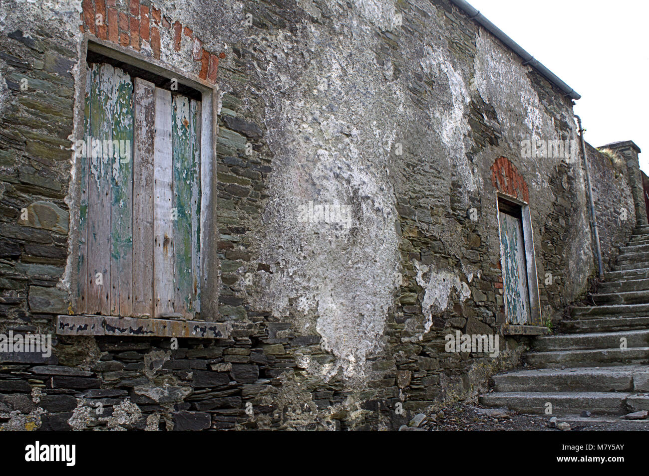 derelict and abandoned boat house side wall with rotten doors in ...