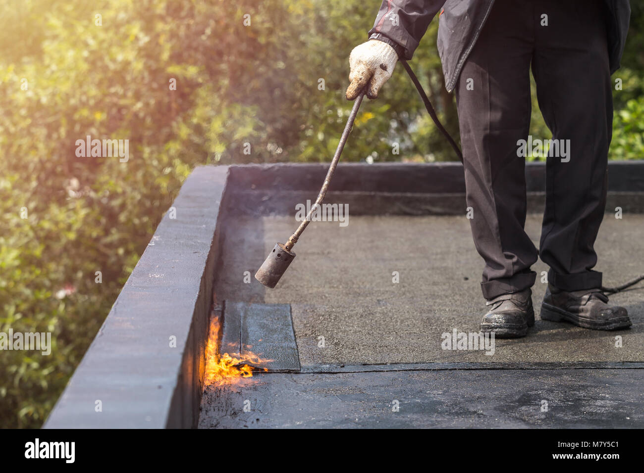 Asia worker installing tar foil on the rooftop of building. Waterproof ...