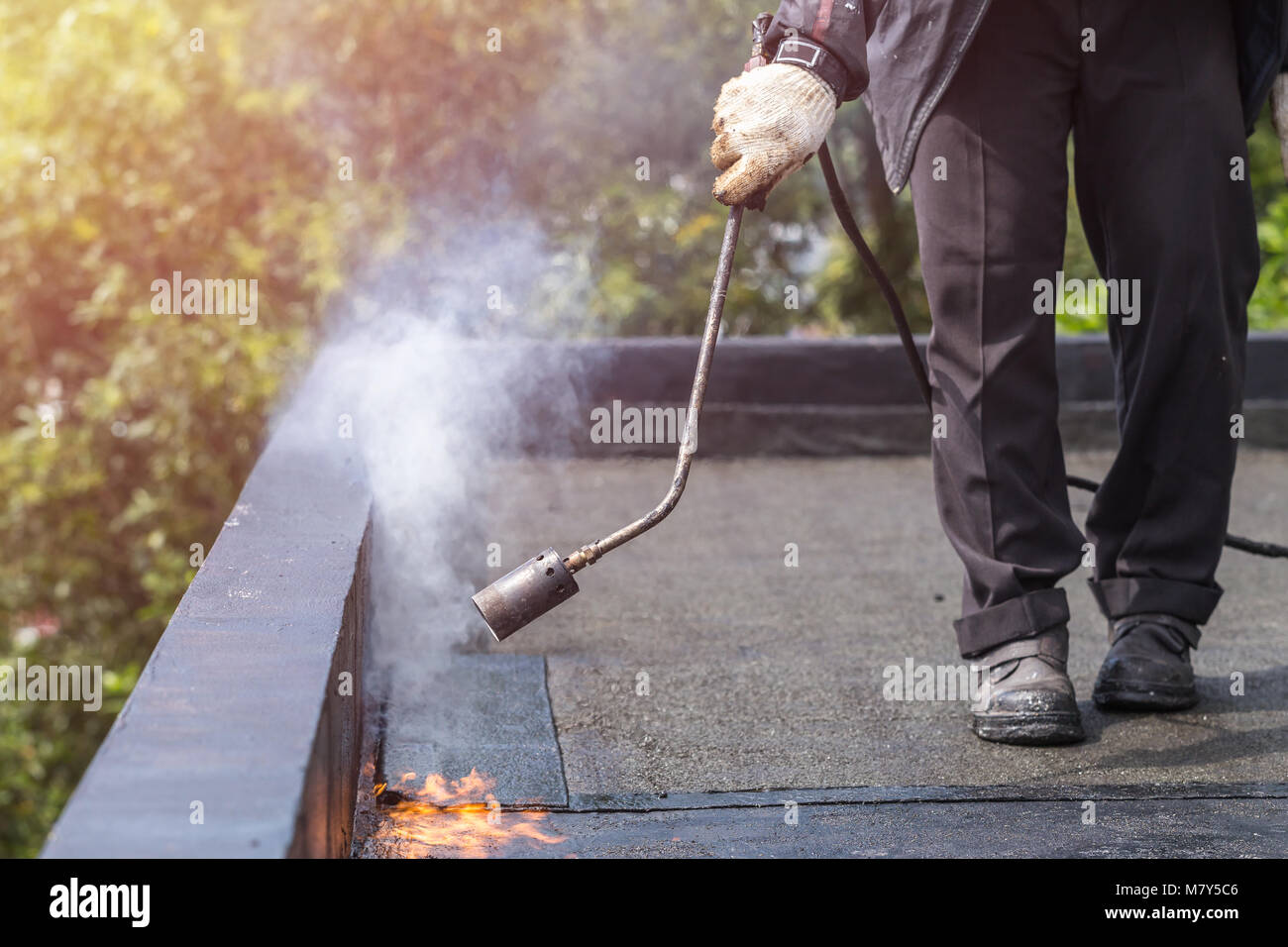 Asia worker installing tar foil on the rooftop of building. Waterproof ...