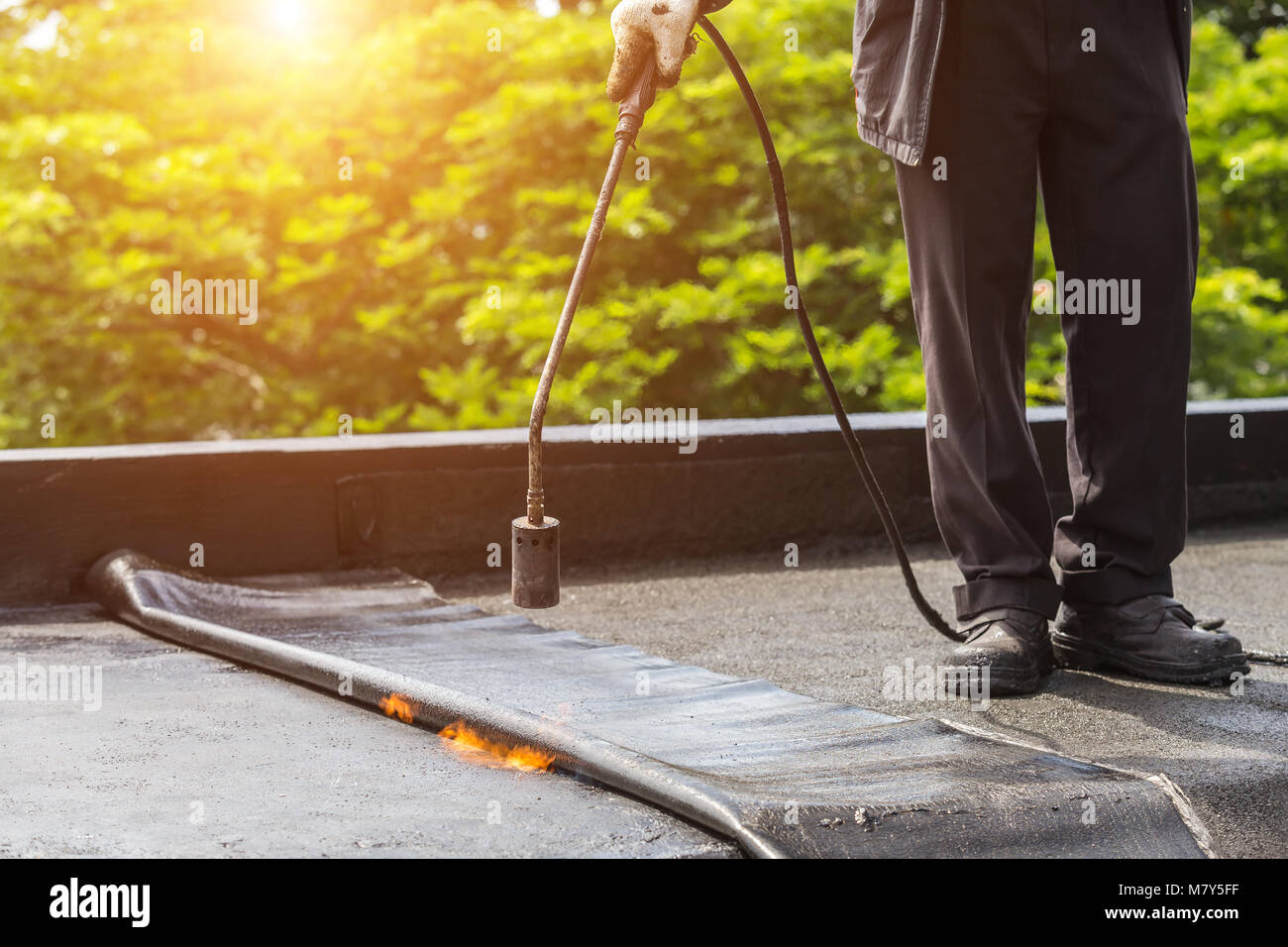 Asia worker installing tar foil on the rooftop of building. Waterproof ...