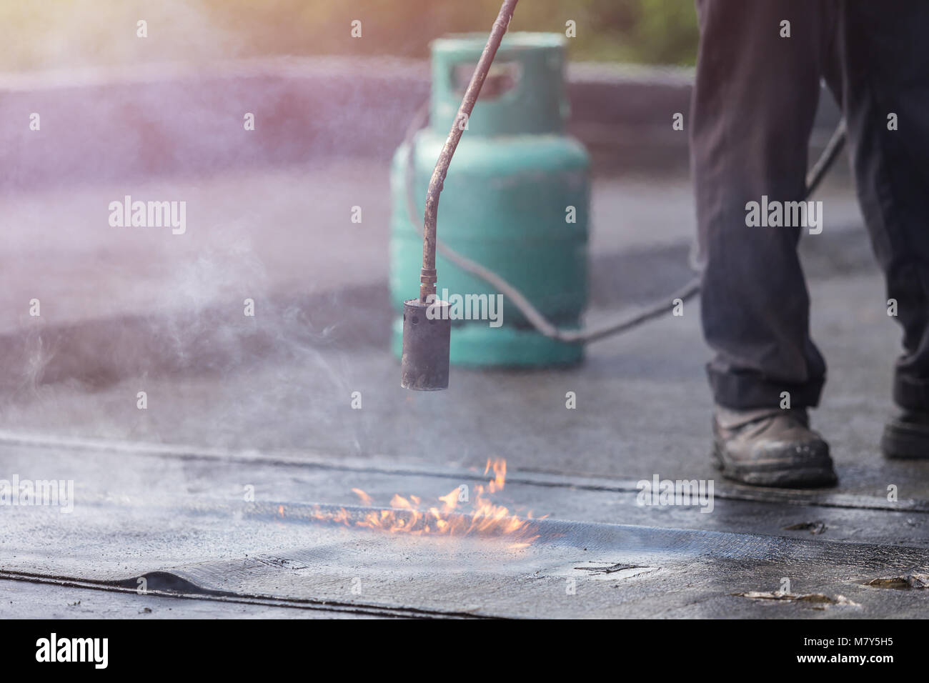 Asia worker installing tar foil on the rooftop of building. Waterproof ...