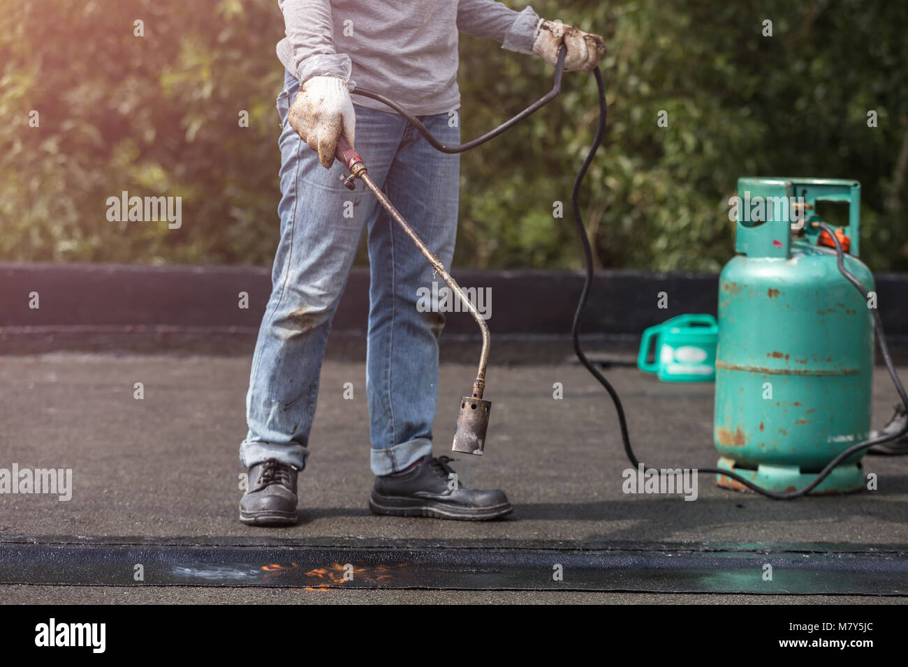 Asia worker installing tar foil on the rooftop of building. Waterproof ...