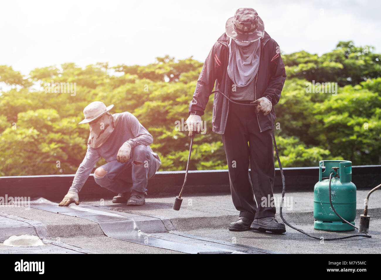 Asia worker installing tar foil on the rooftop of building. Waterproof ...