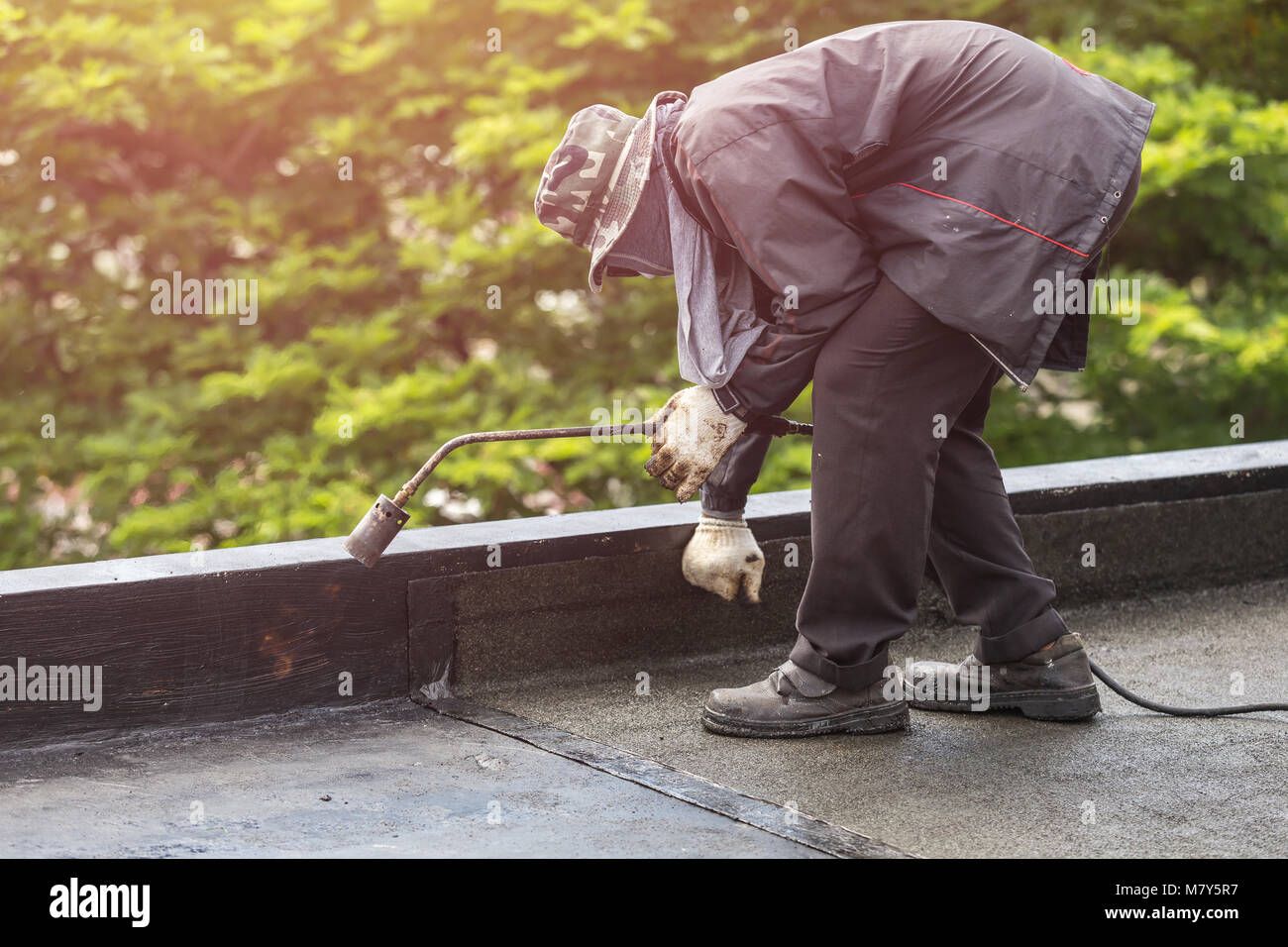 Asia worker installing tar foil on the rooftop of building. Waterproof ...