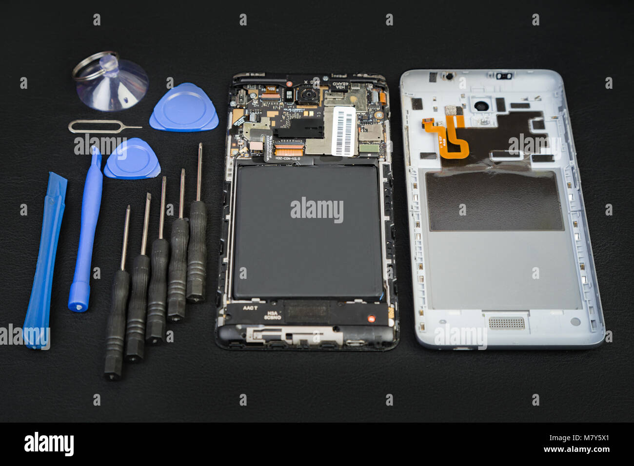 Disassembled phone and special purpose tools on the black table ...