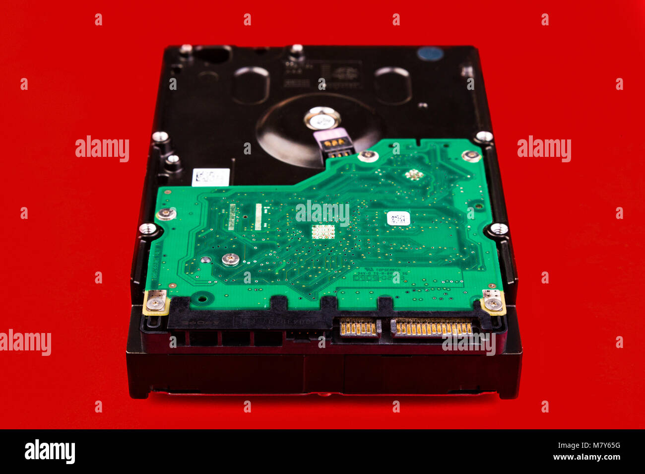 Computer hard drive, front view, on a red background. Data storage ...