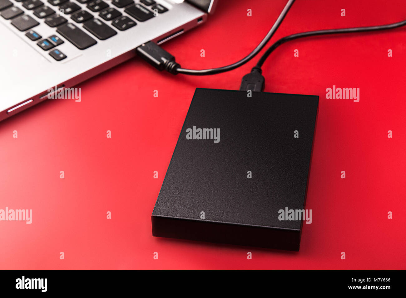 An external hard drive connected to the laptop with a usb cable on a ...