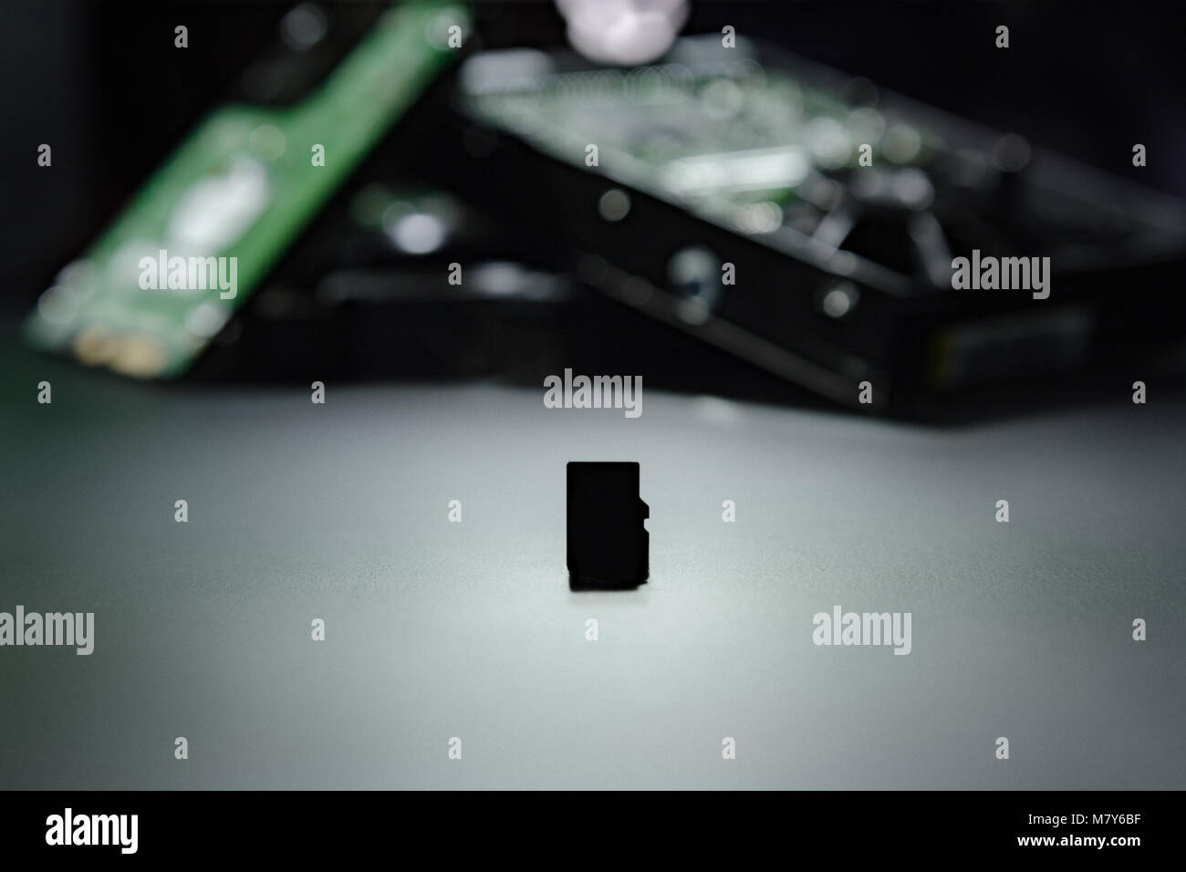 Silhouette of micro SD cards on the background of hard drives as a ...