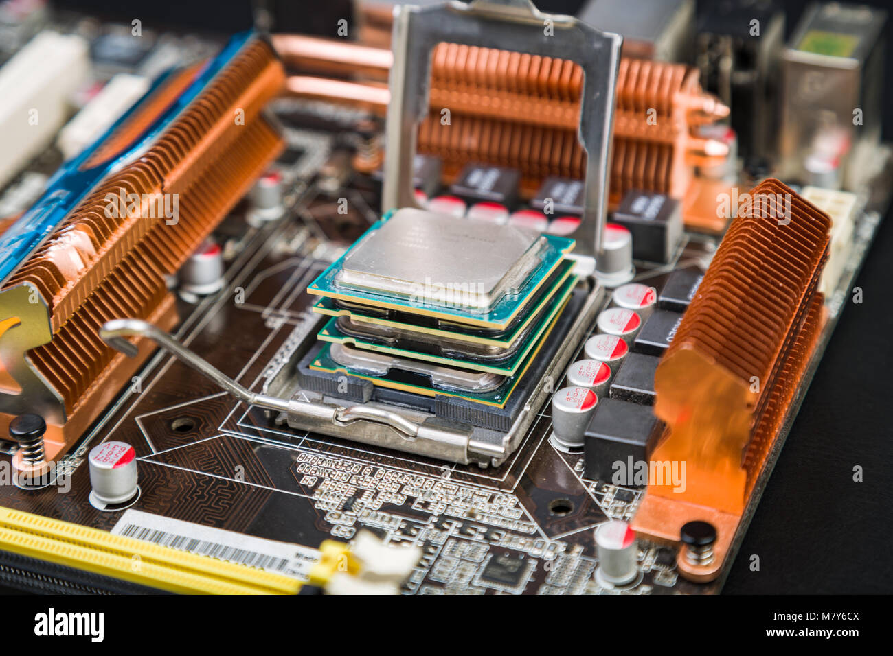 Four processors in an old and dusty game motherboard, lying on top of ...