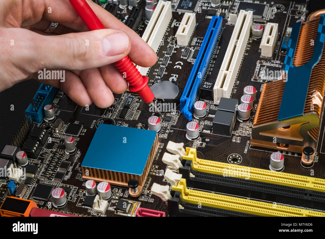 Workplace repairman computers. Fixing an old motherboard with a ...