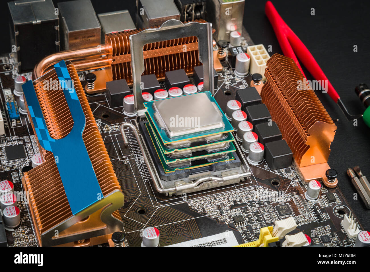 Four processors lie on top of each other in the motherboard with orange ...
