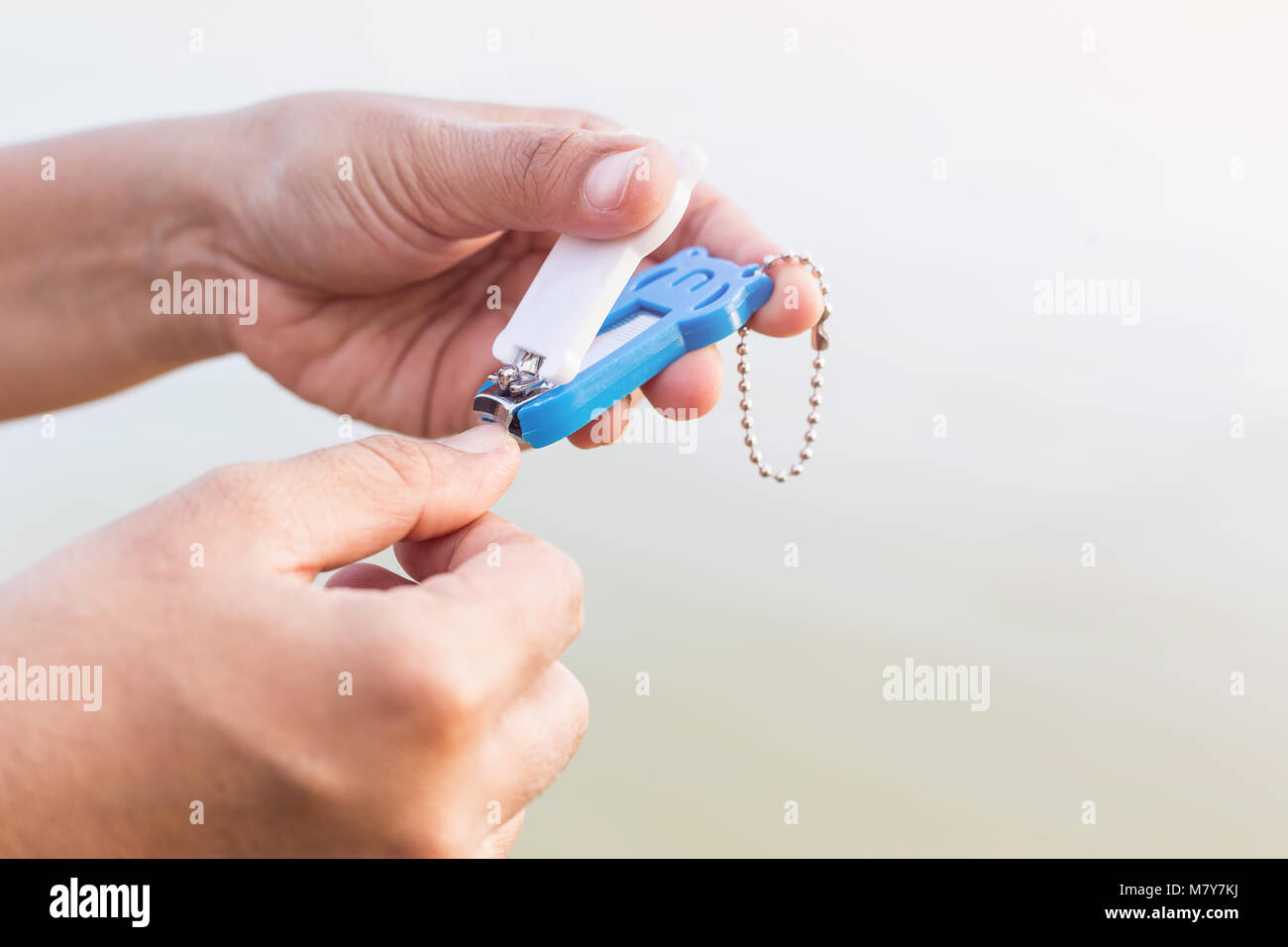 Close up woman cutting her nails using nail clipper Stock Photo - Alamy
