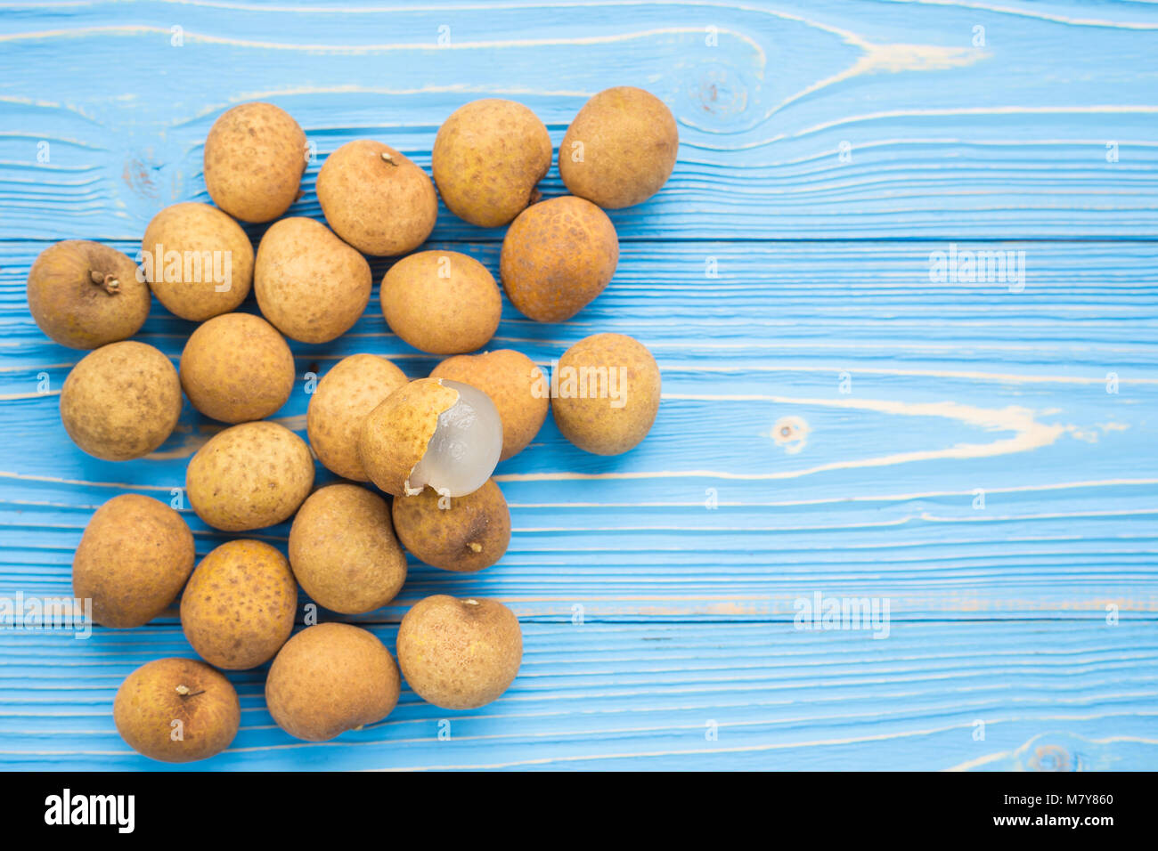 Close up fresh longan tropical fruit on blue wooden plank background ...