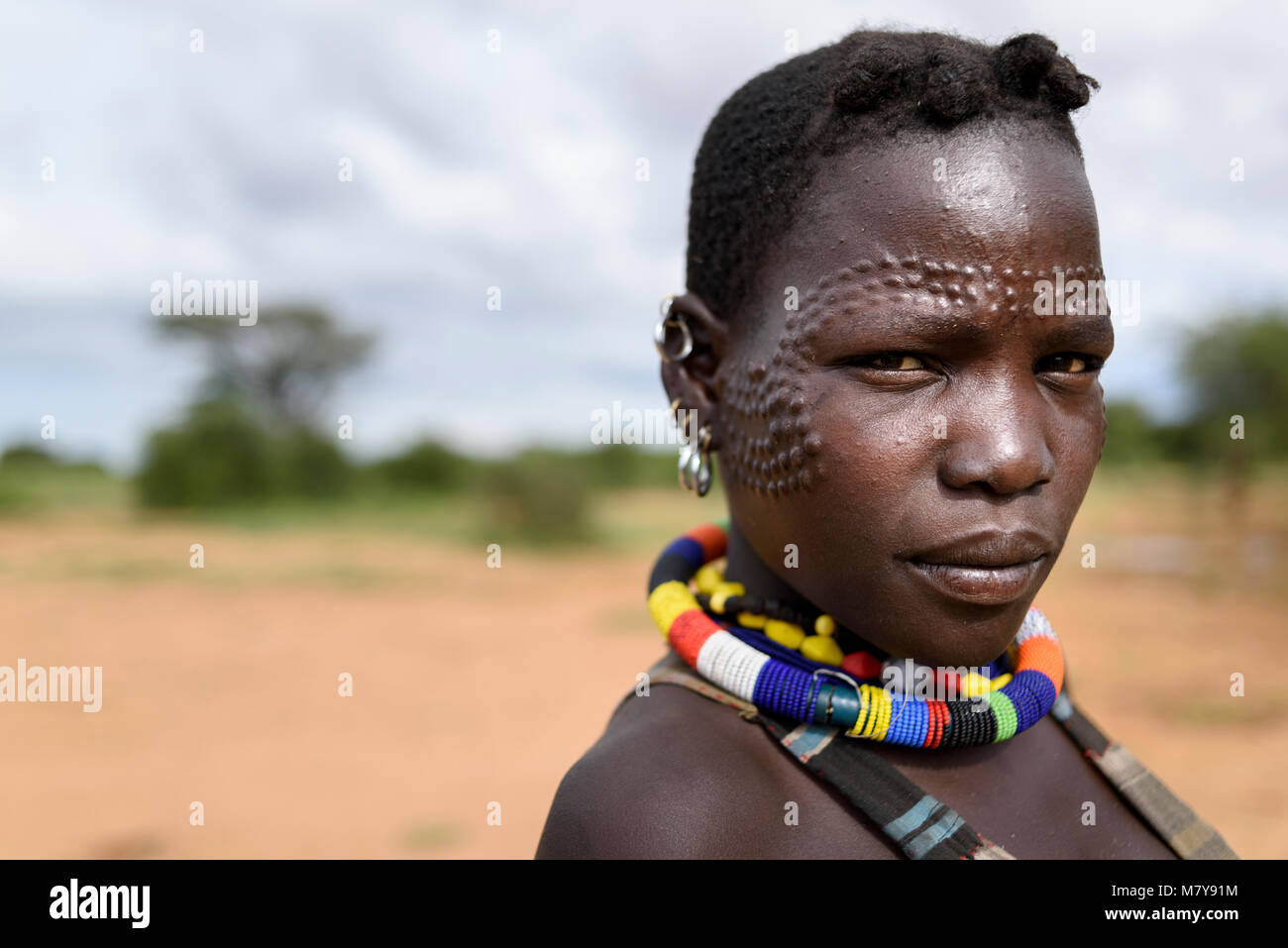 Portrait of a young Karamajong woman with traditional scars on her face ...