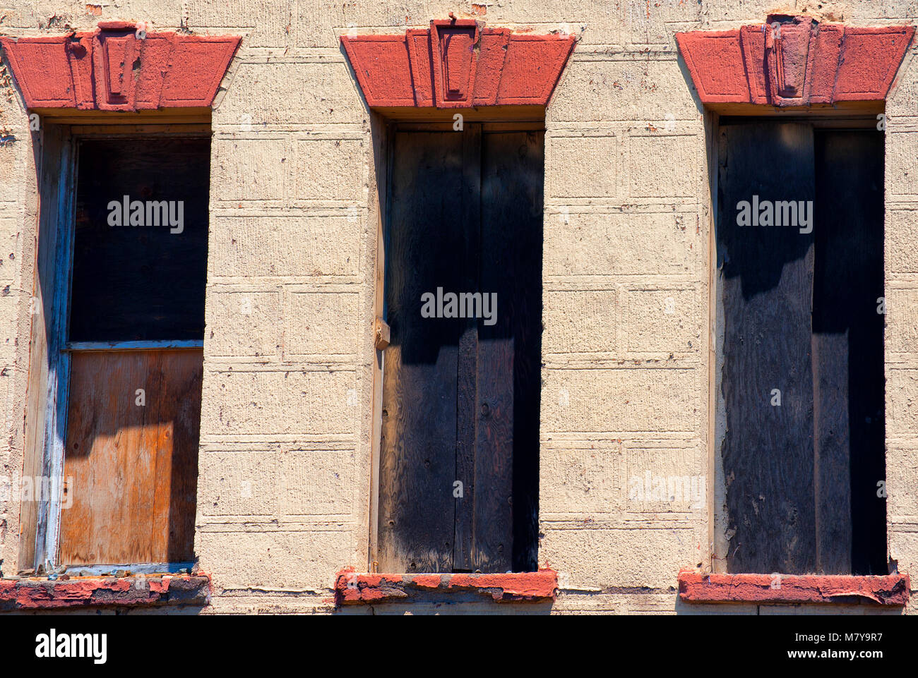 Section of an old abandoned building with boarded up holes where ...