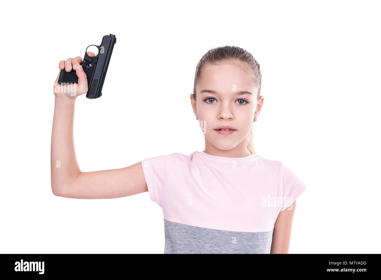 Young girl holding a gun in her hand pointing upwards, isolated on a ...