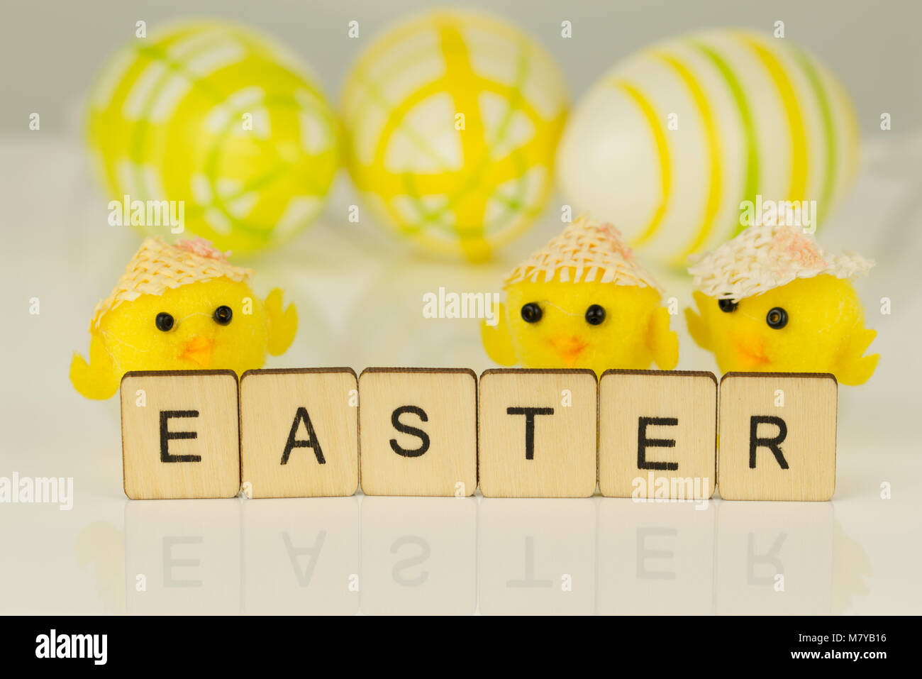 The word Easter written in letter tiles on reflective white surface ...