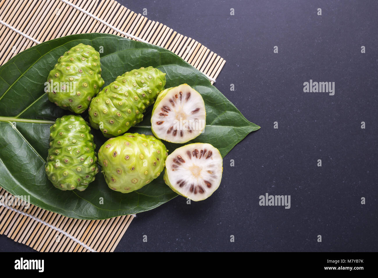Fruit of Great morinda (Noni) or Morinda citrifolia tree and green leaf ...