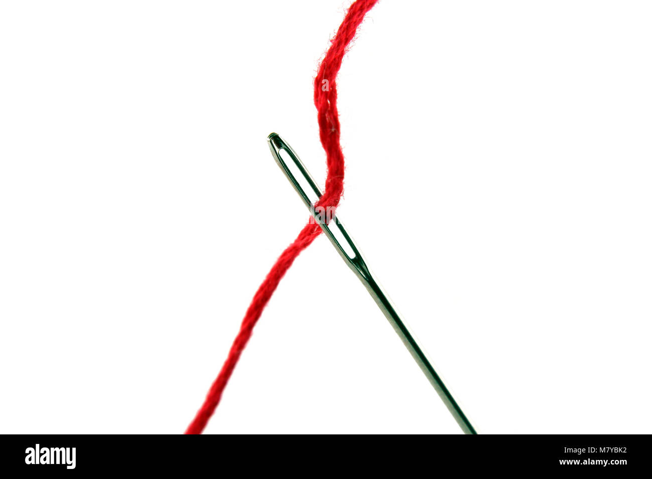 A Needle and red thread over white Stock Photo - Alamy