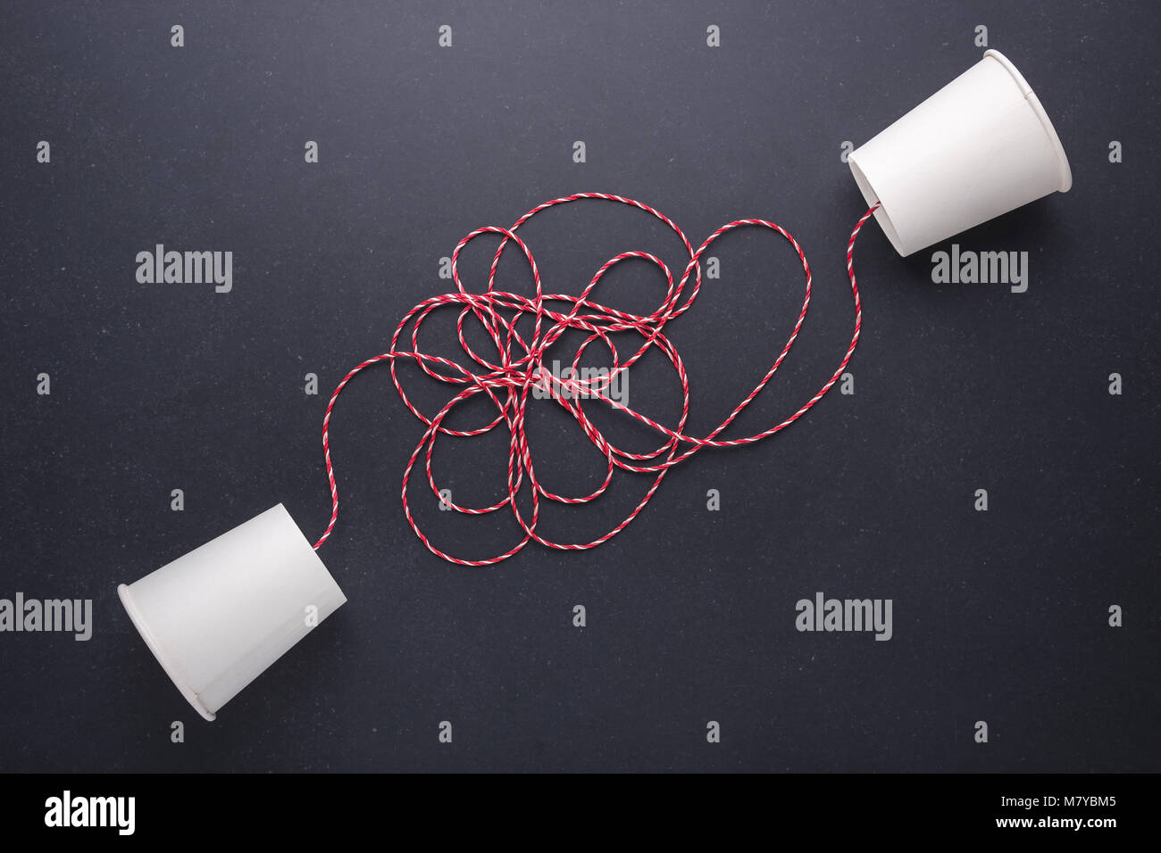 Two white paper cup connect with red rope used for classic phone on ...