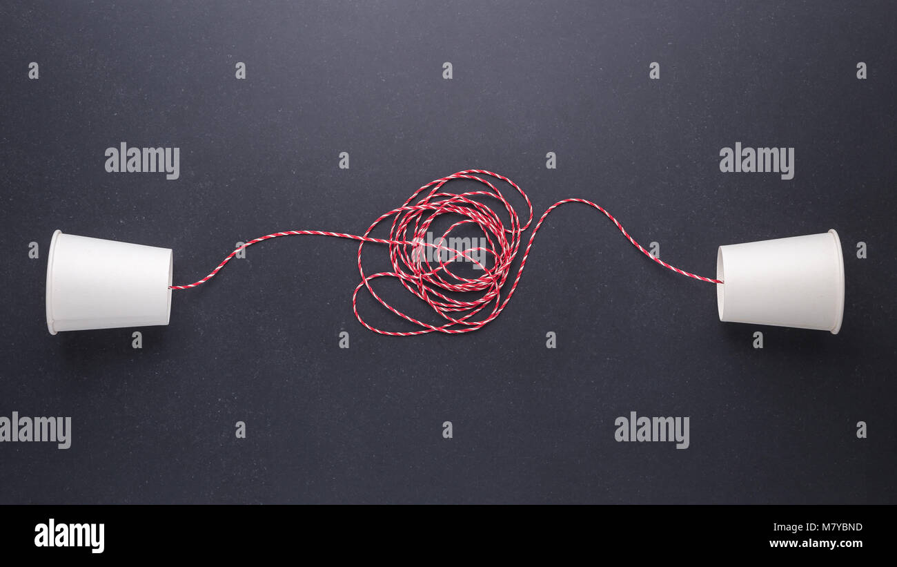 Two white paper cup connect with red rope used for classic phone on ...