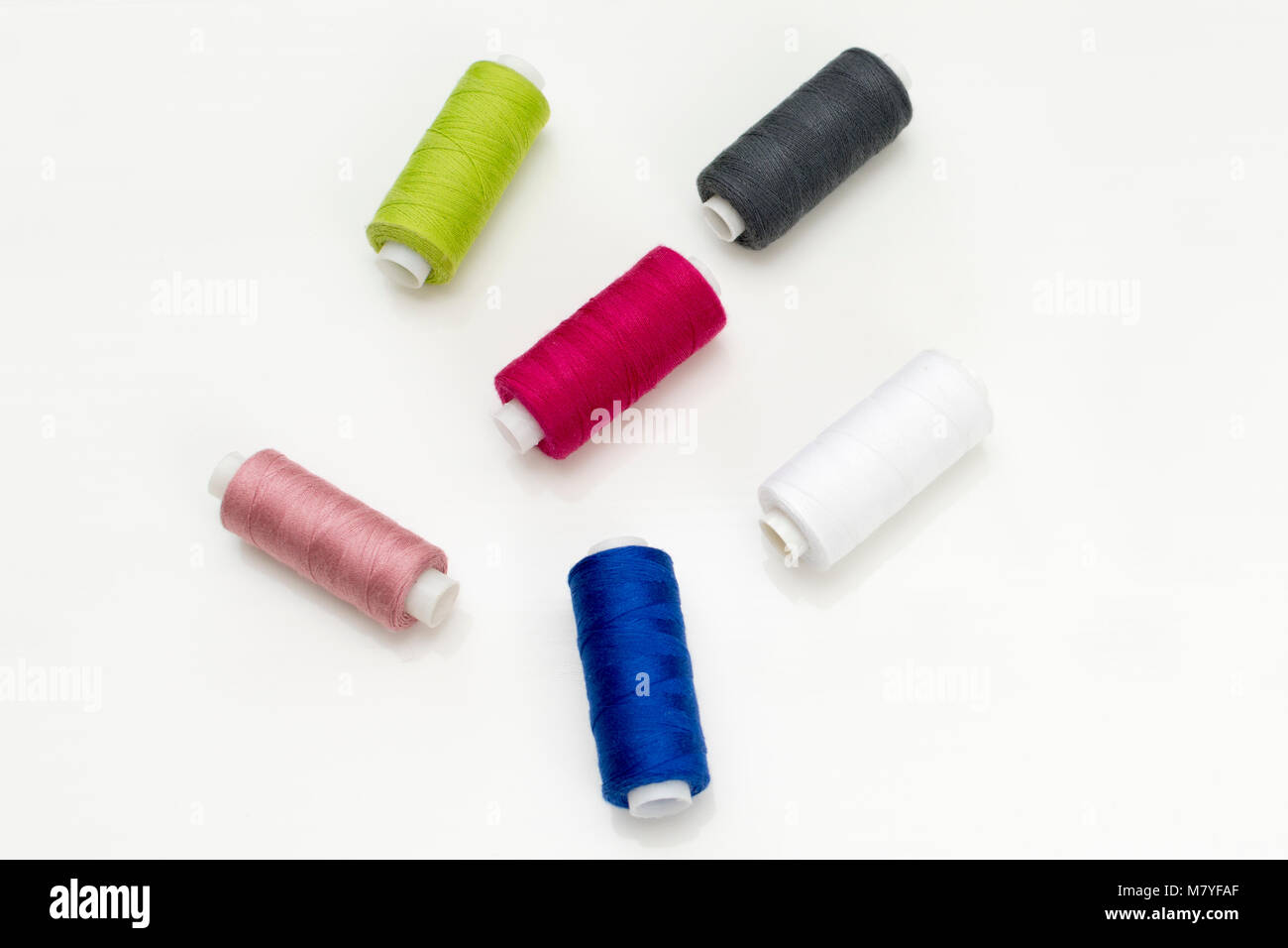 Colored thread coils on white background, sewing, place for text Stock ...