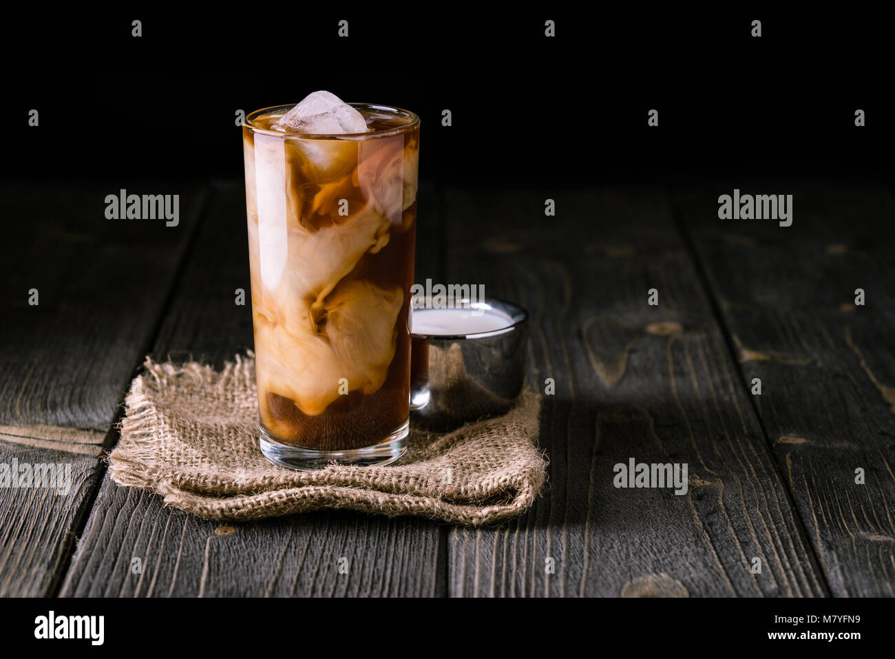 Iced coffee in a tall glass with ice on top Stock Photo - Alamy