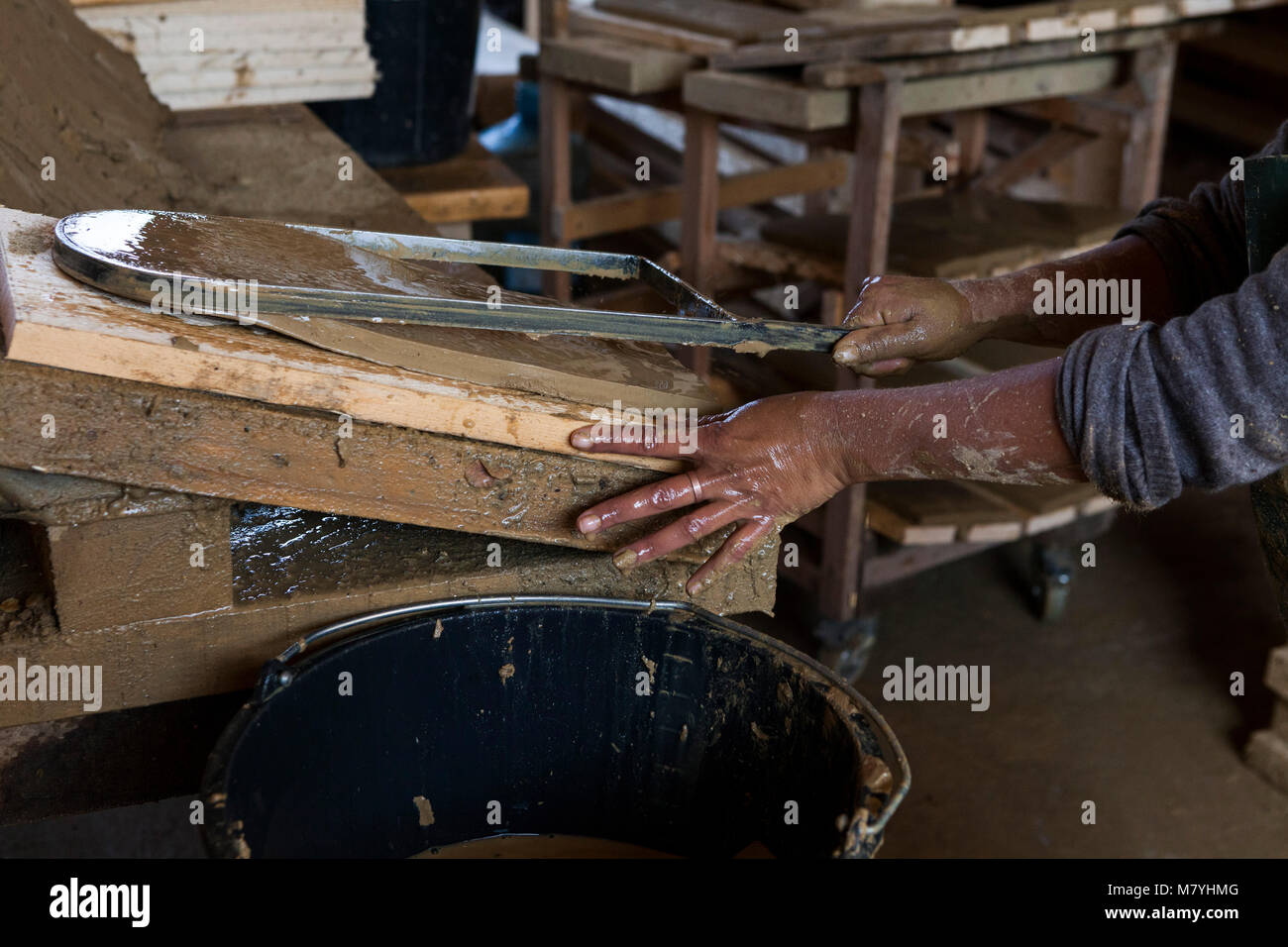 People making roof tiles from clay using traditional methods in ...