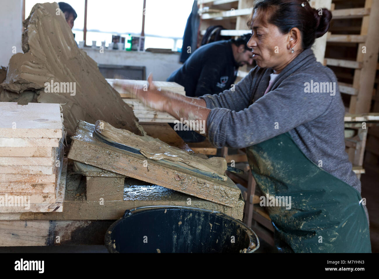 People making roof tiles from clay using traditional methods in ...