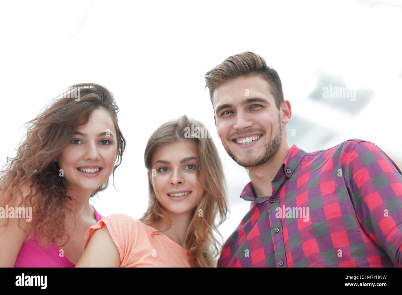 closeup of three young people smiling on white background Stock Photo ...