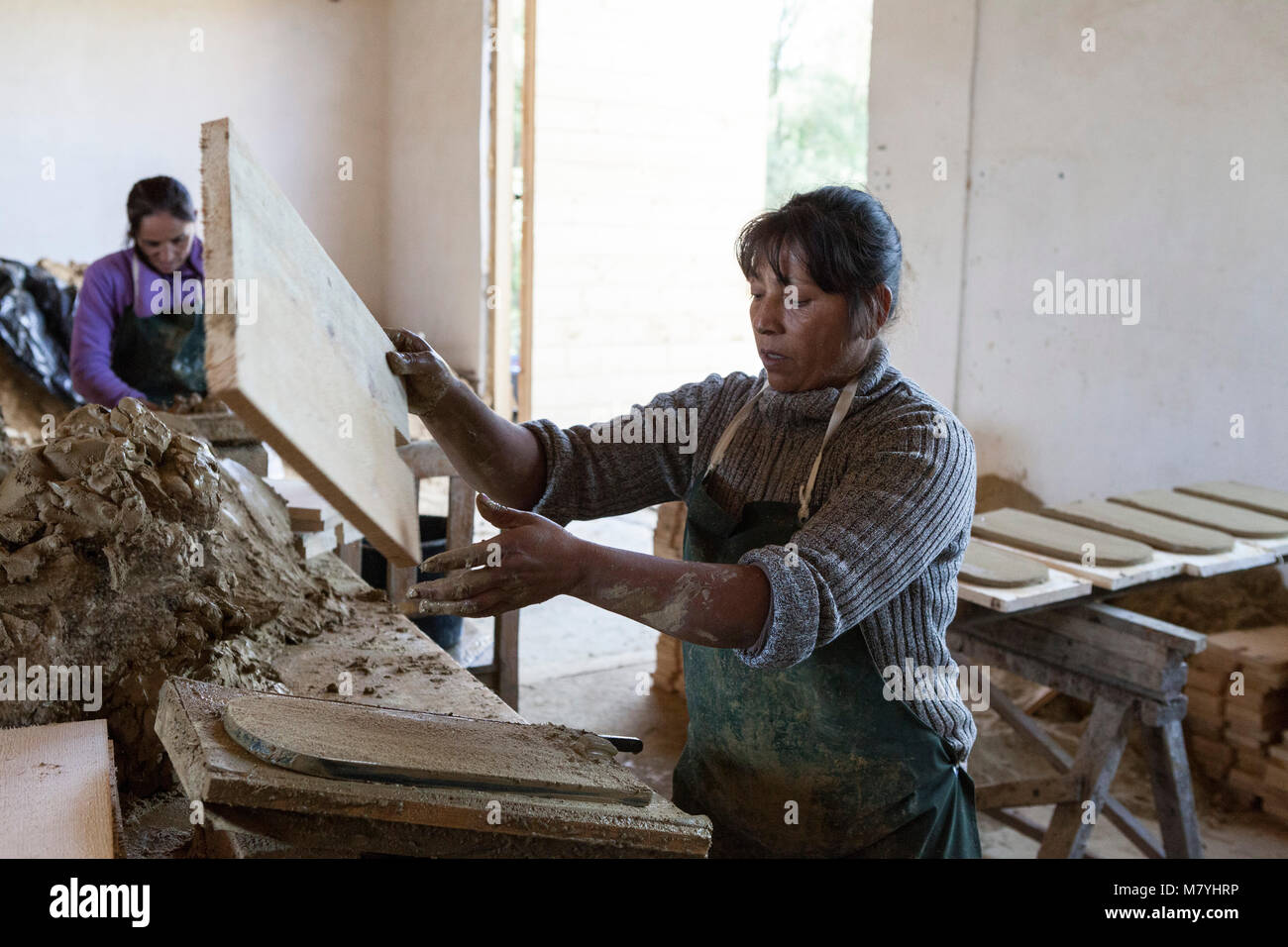 People making roof tiles from clay using traditional methods in ...