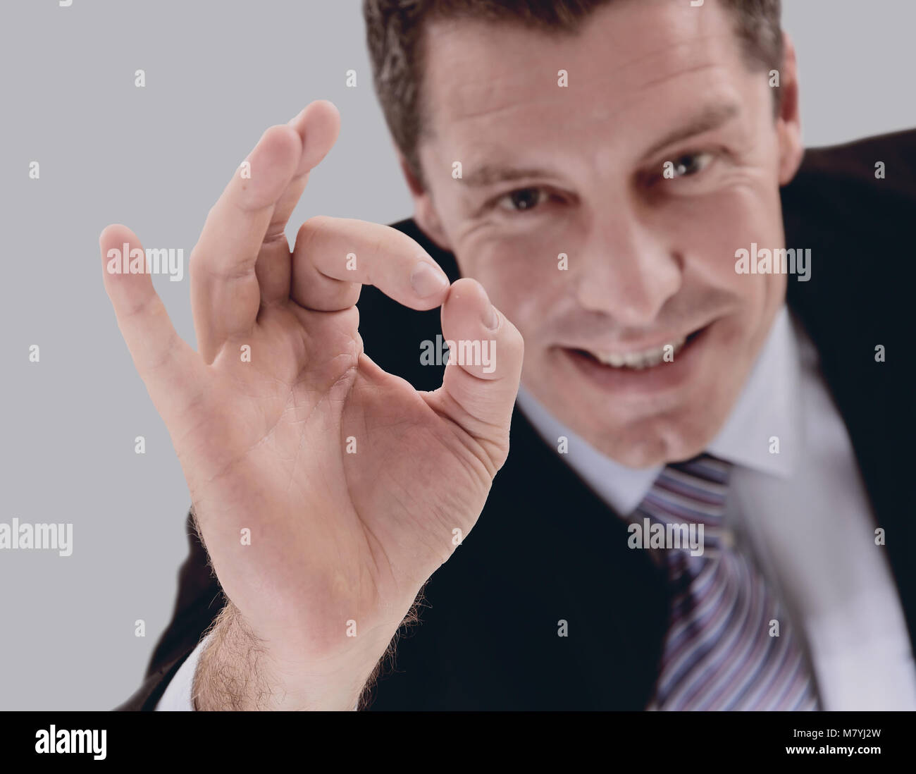 Happy young man in suit gesturing OK sign and smiling Stock Photo - Alamy