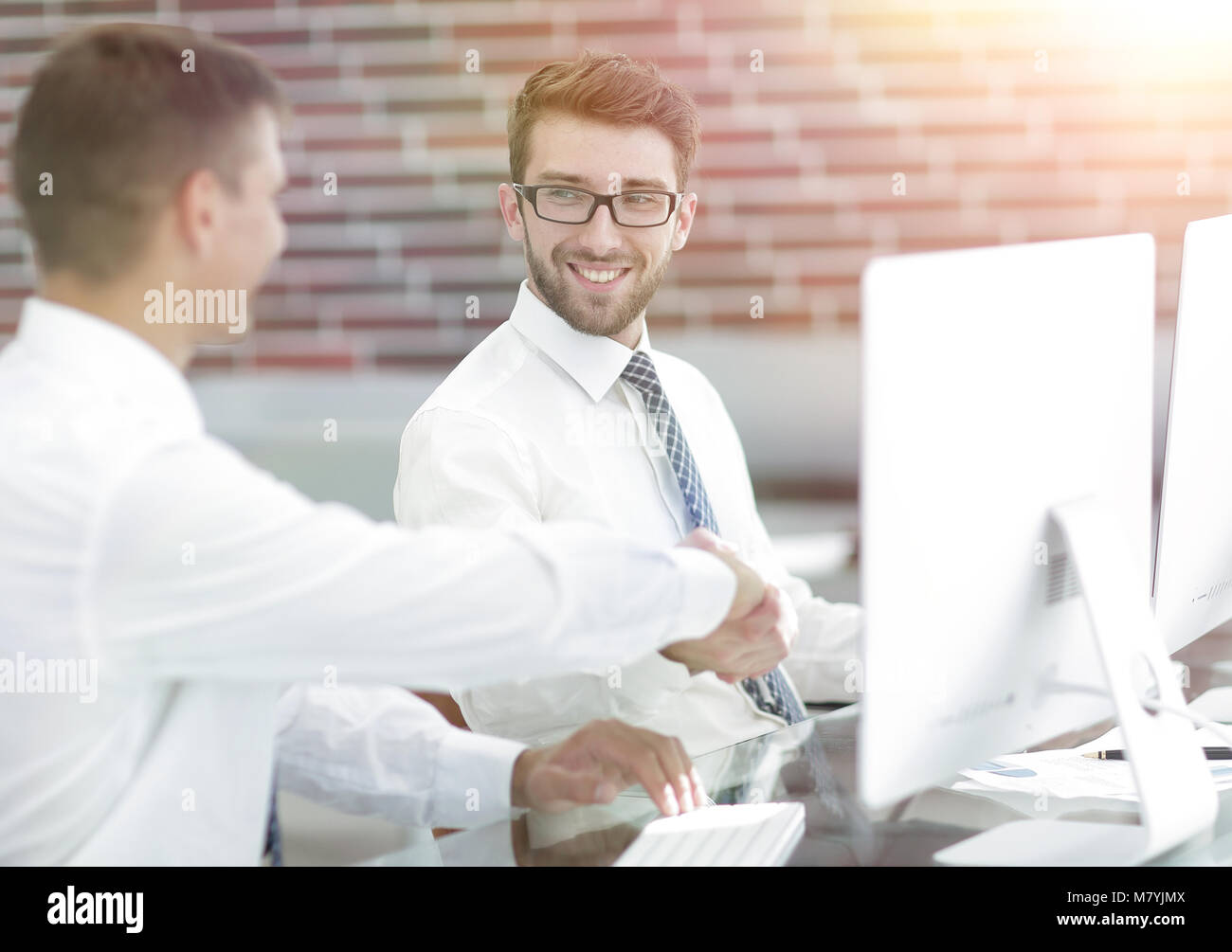 handshake of the employees at the Desk Stock Photo - Alamy