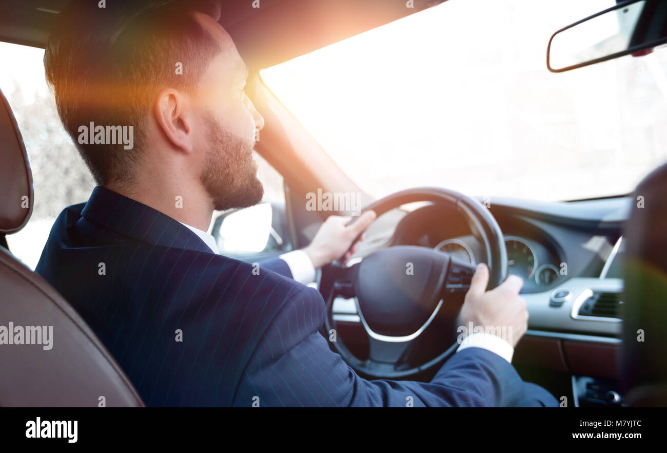 businessman sits at the wheel in his car and looks at the road Stock ...
